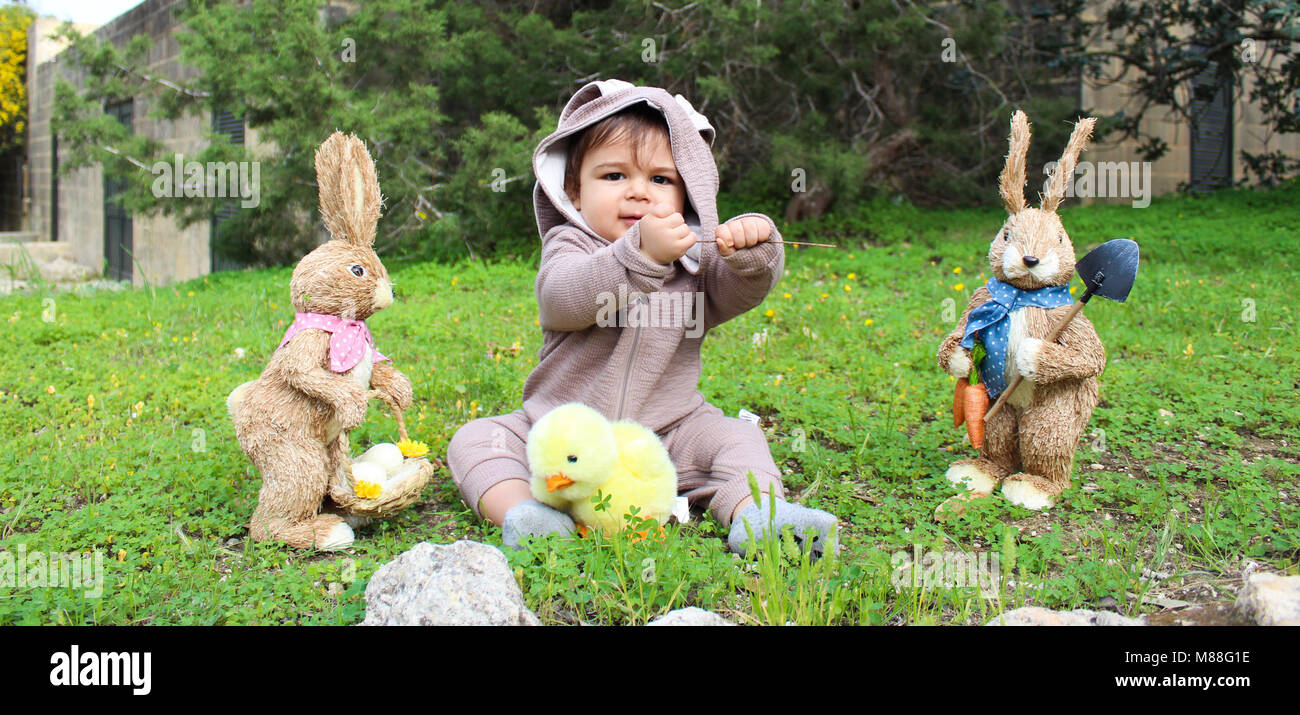 one year baby boy playing on the grass in rabbit suit Stock Photo - Alamy