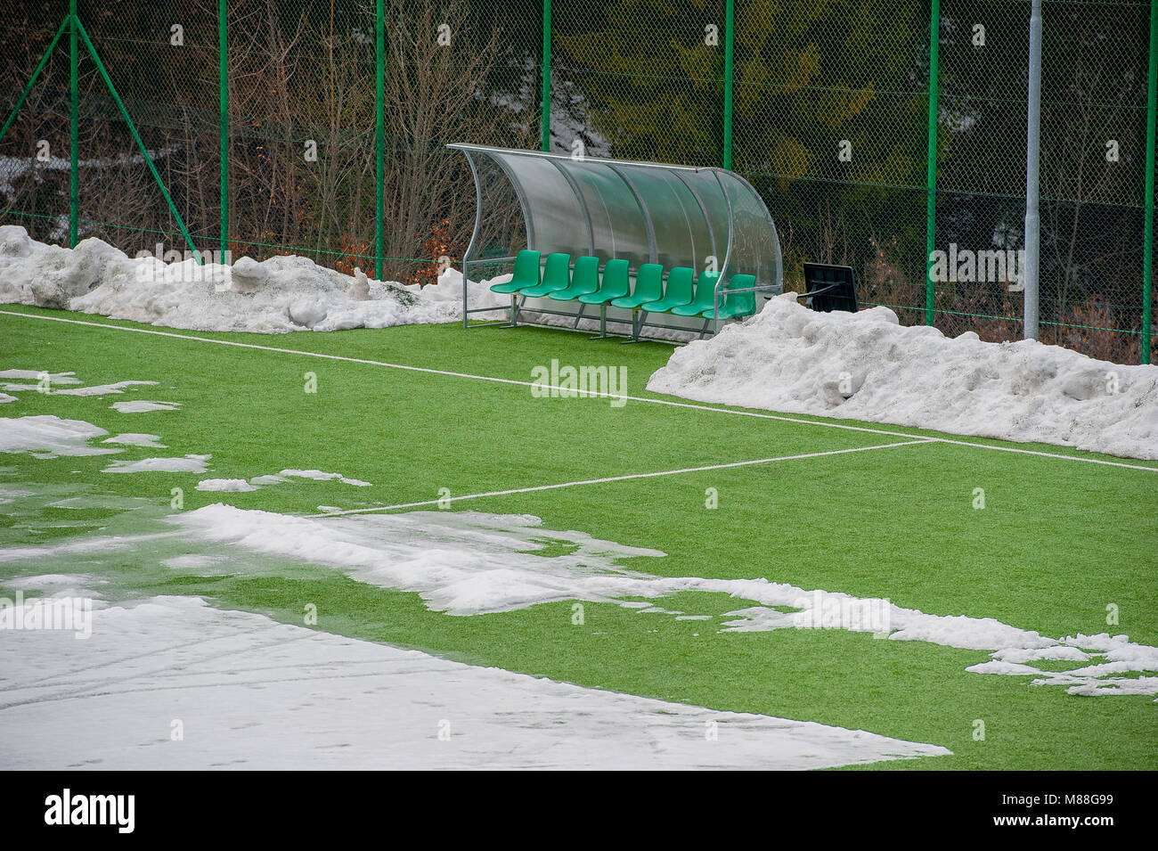 Synthetic soccer field covered with snow Stock Photo - Alamy