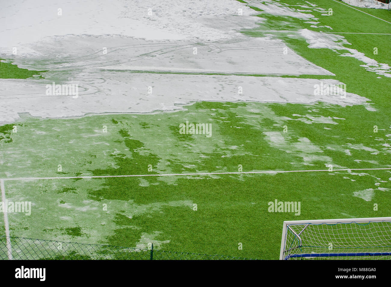 Synthetic soccer field covered with snow Stock Photo - Alamy