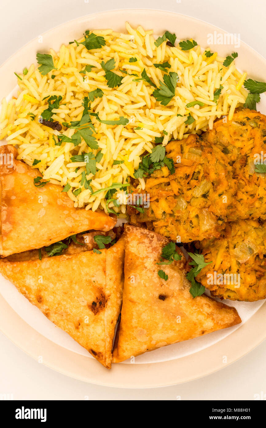 Onion Bhajis And Samosas With Pilau Rice Against A Grey Background ...