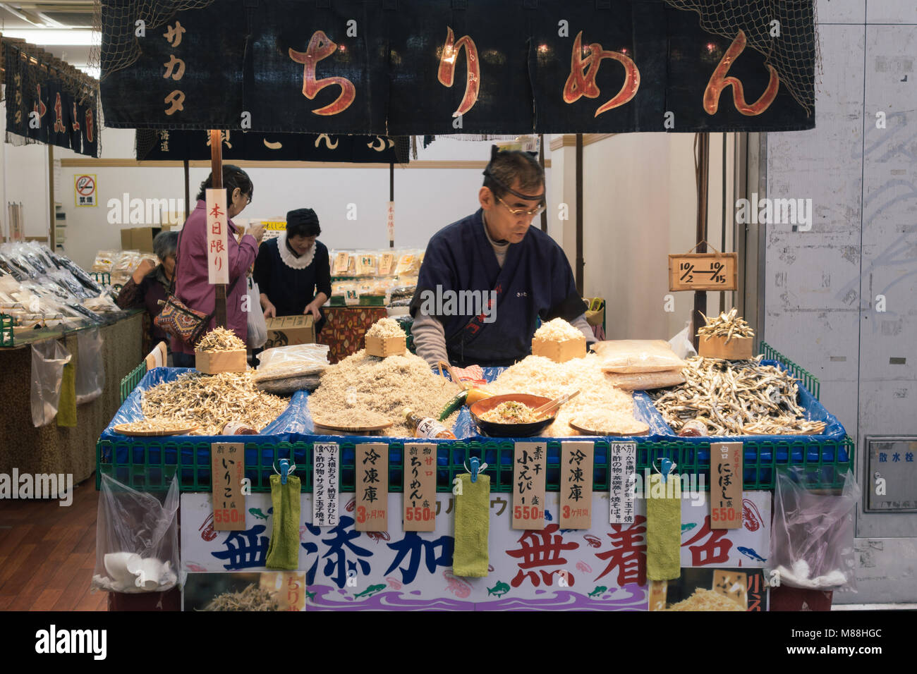 Japanese vendor in his stall, selling seafood and local food in the ...
