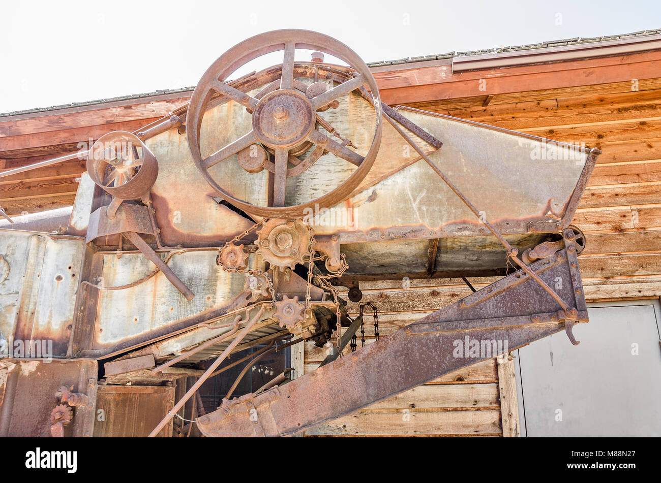 Wheels, gears, and chains on a rusty threshing machine Stock Photo - Alamy
