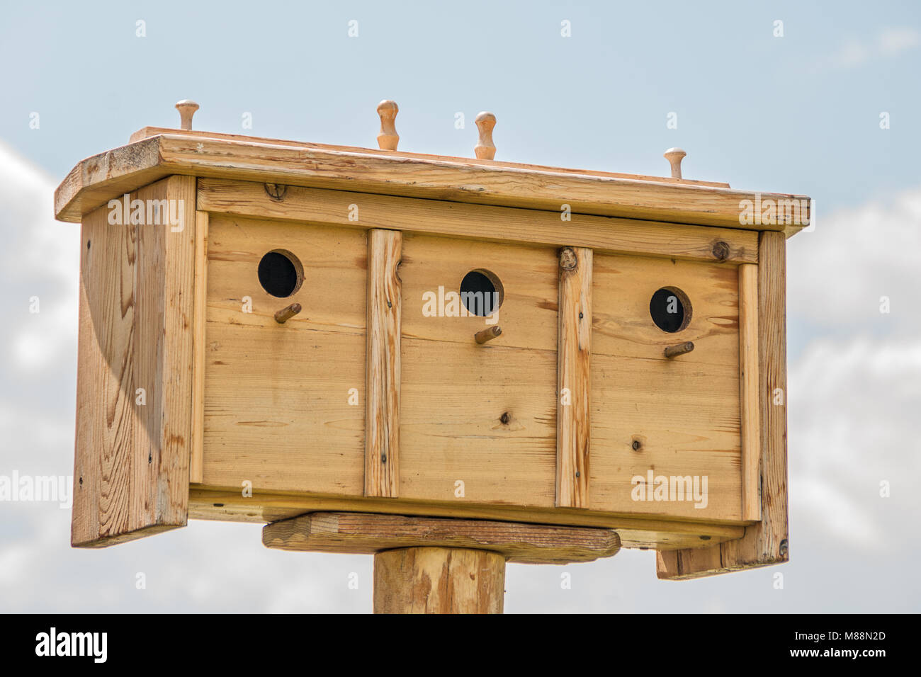 Three birdhouses built as one multi-family unit Stock Photo - Alamy