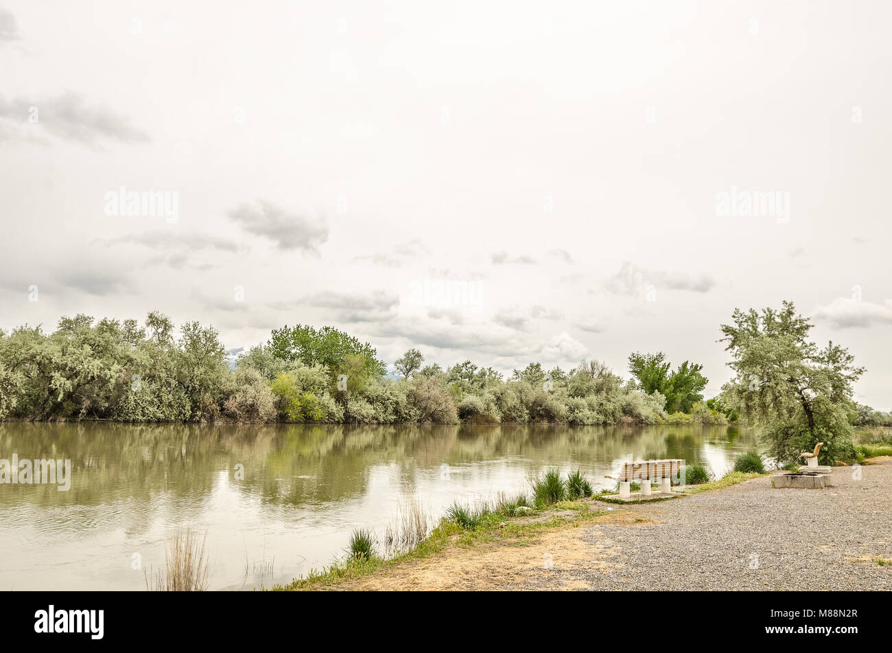 Peaceful stretch of a river with benches for relaxing and enjoying the ...