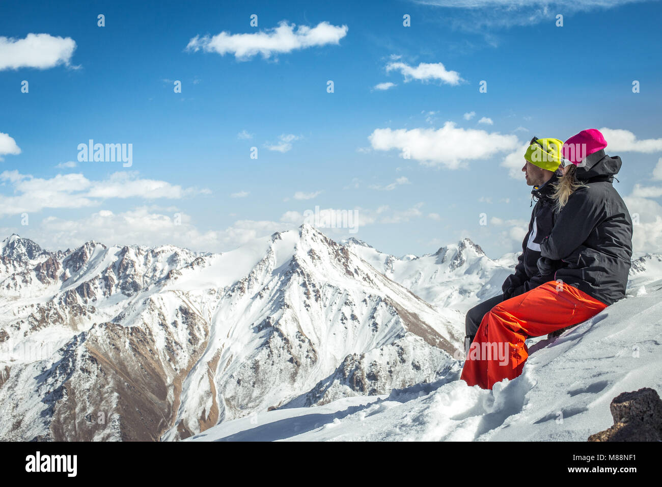 Couple of hikers are sitting on the top of Tourist peak and watching ...