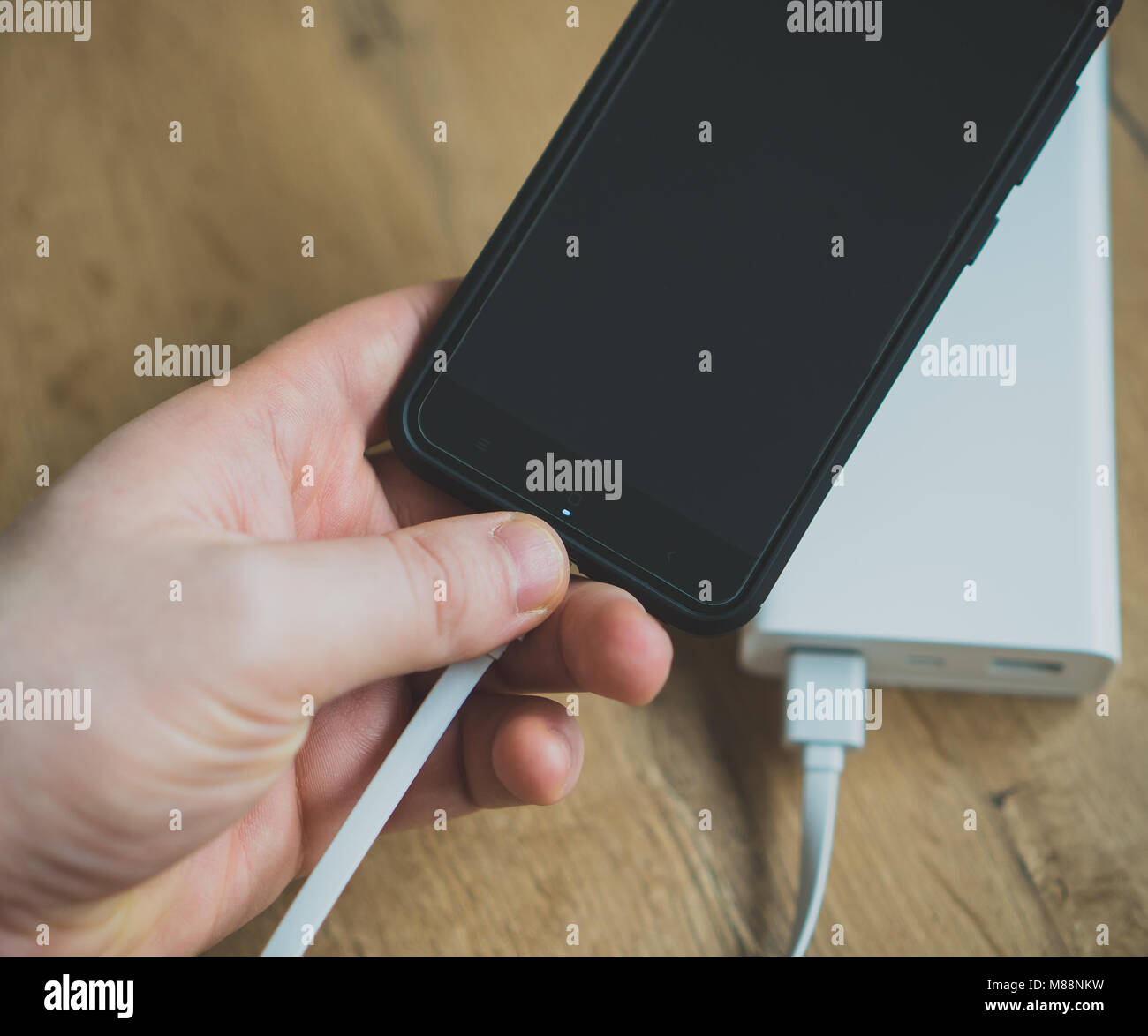 Man charging smartphone with power bank Stock Photo - Alamy