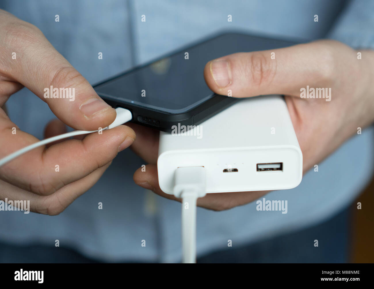 Man charging smartphone with power bank Stock Photo - Alamy