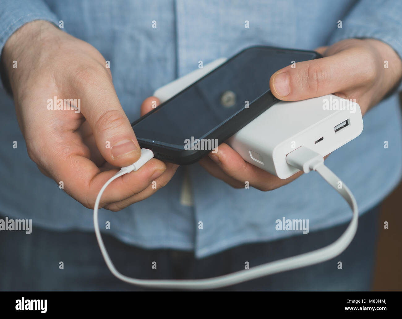 Man charging smartphone with power bank Stock Photo - Alamy