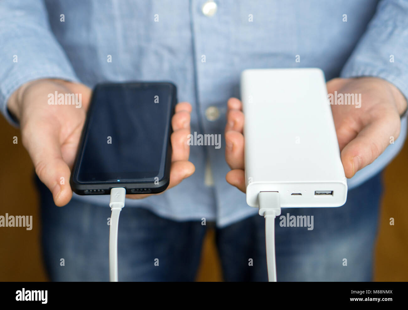 Man charging smartphone with power bank Stock Photo - Alamy