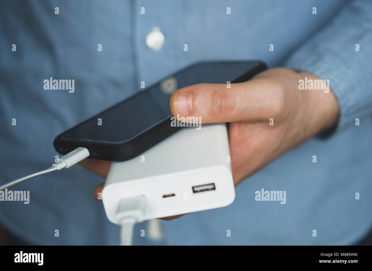Man charging smartphone with power bank Stock Photo - Alamy