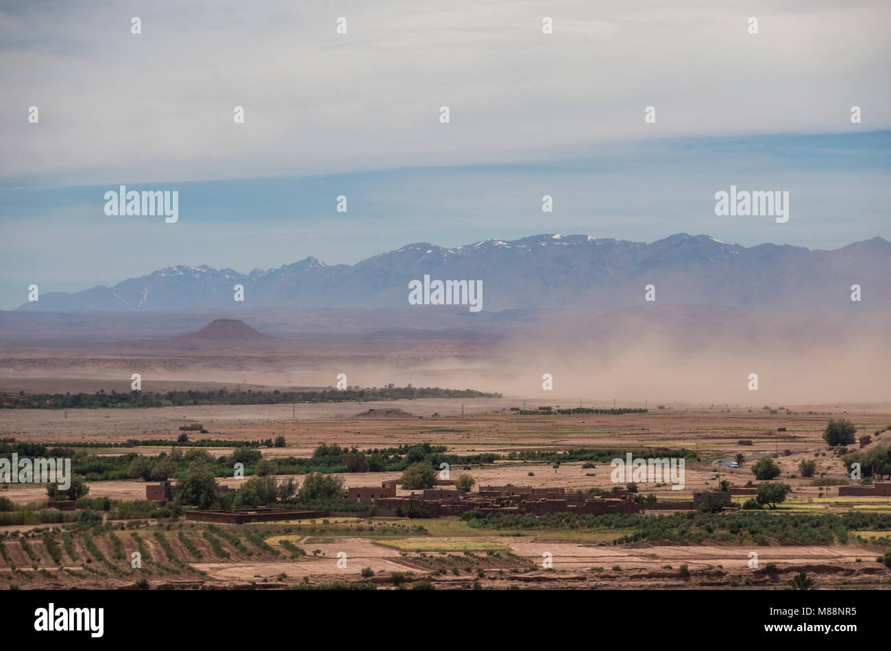 Sandstorm in valley near of High Atlas mountain range. With snow on the ...