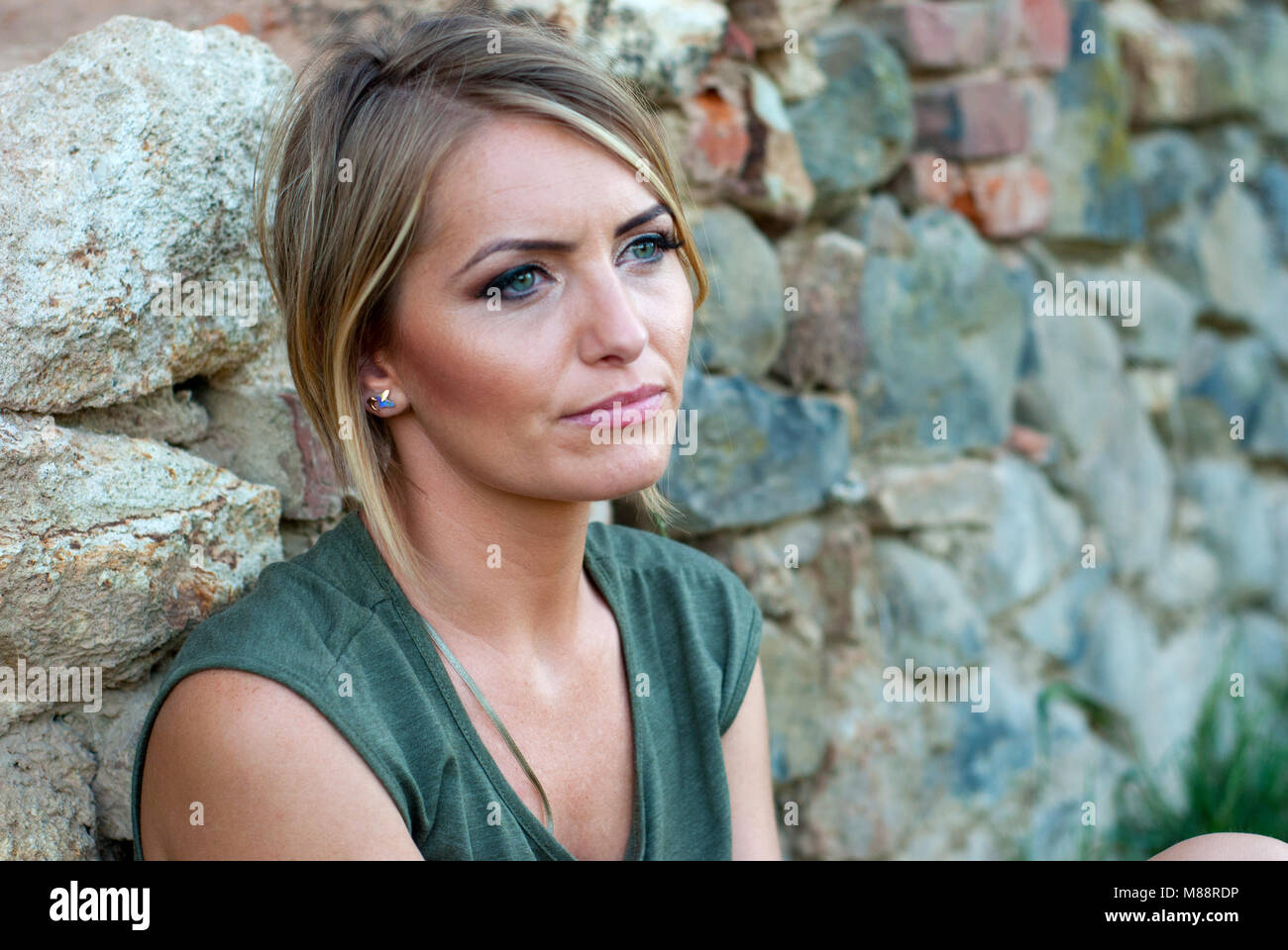 Outdoor portrait of a sad, moody or depressed, beautiful blonde woman ...