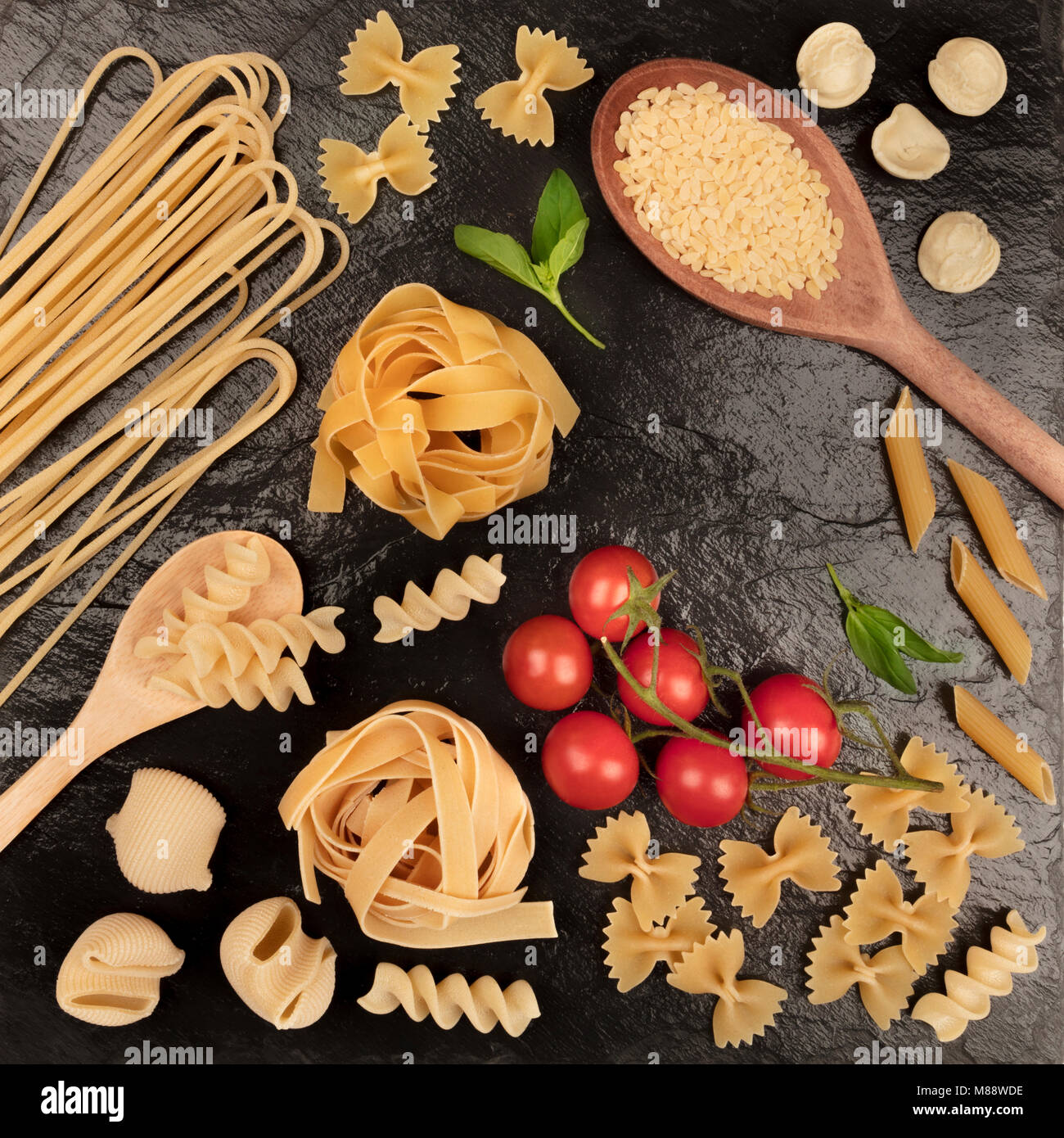 An overhead square photo of different types of pasta, including ...
