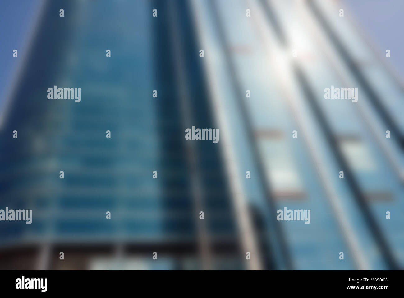 Low angle exterior of defocused tall modern glass skyscraper against a ...