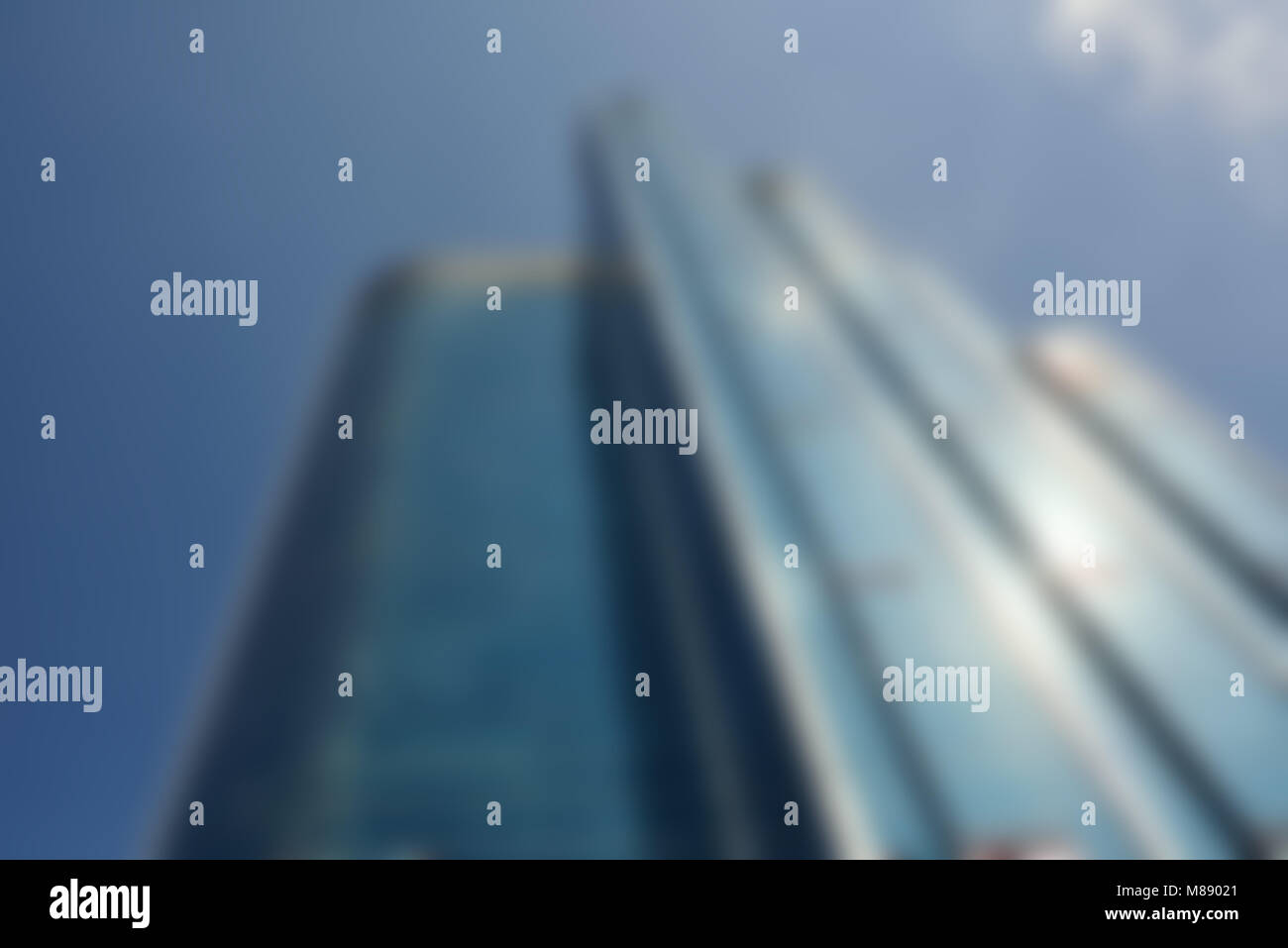 Low angle exterior of blurred modern glass skyscraper in the commercial ...