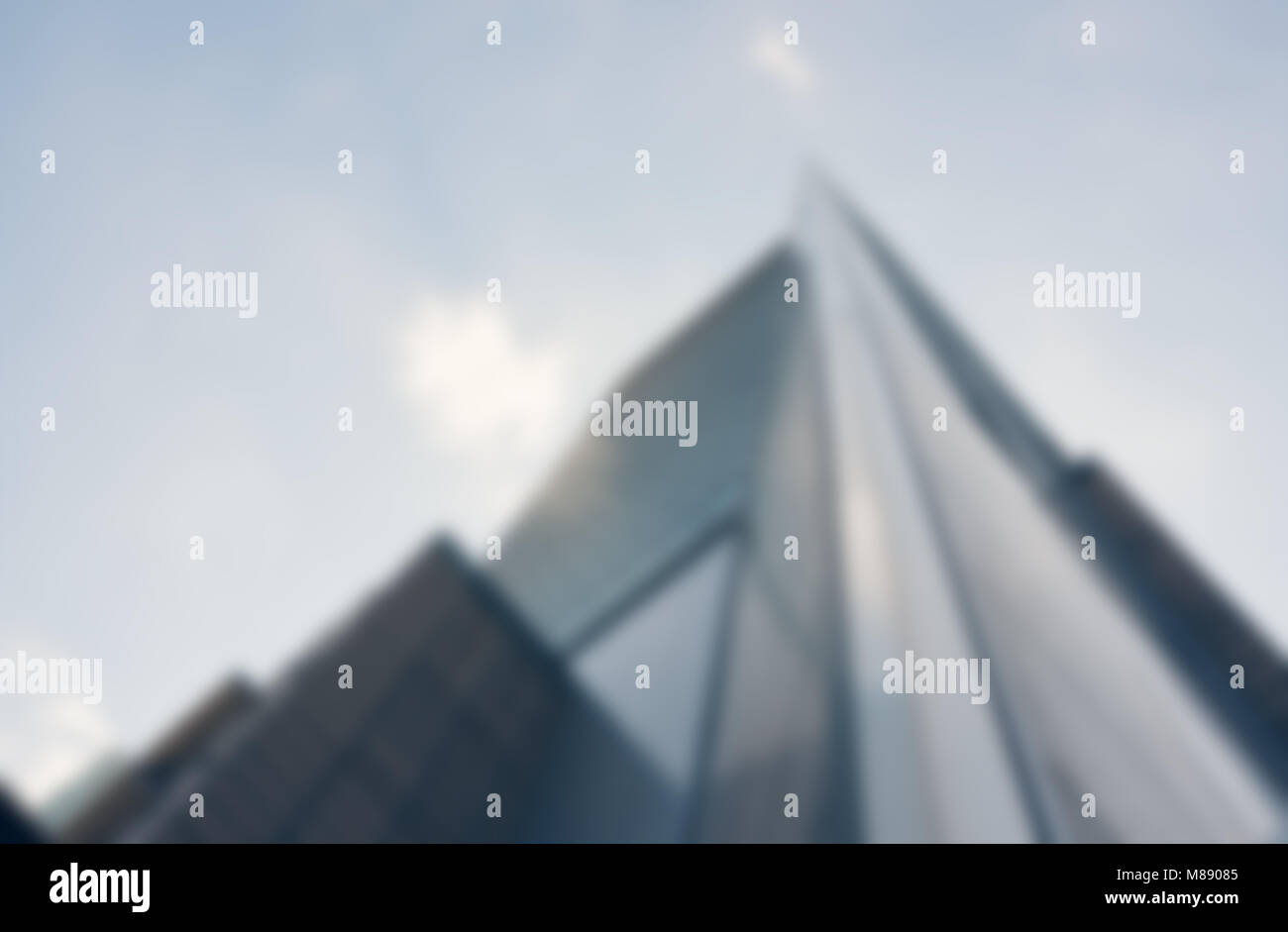 Blurred low angle image of a large modern glass skyscraper rising up ...