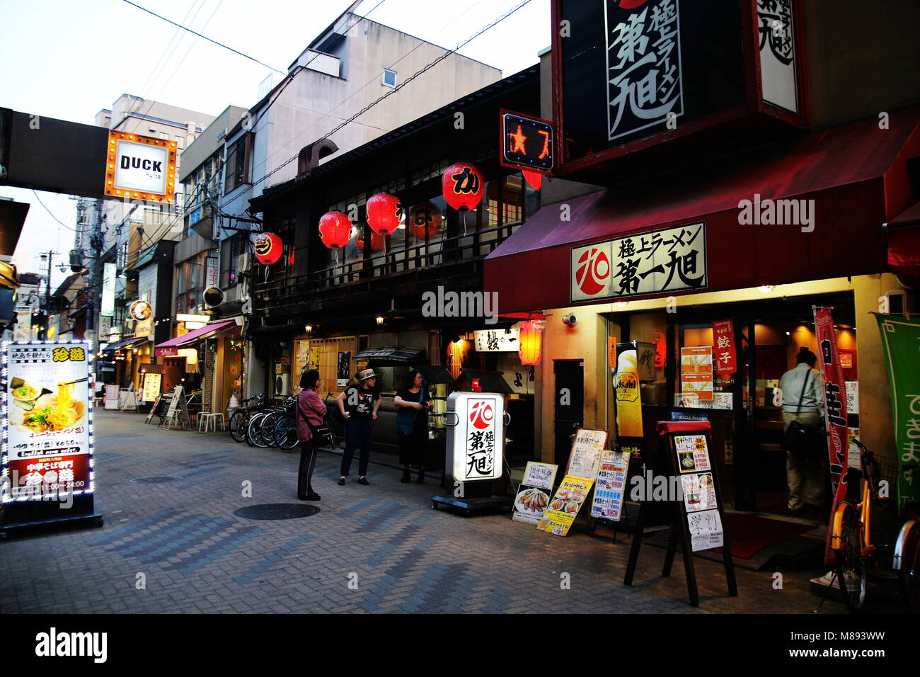 Narrow street with restaurants in Kyoto, Japan at dusk. Menu display ...