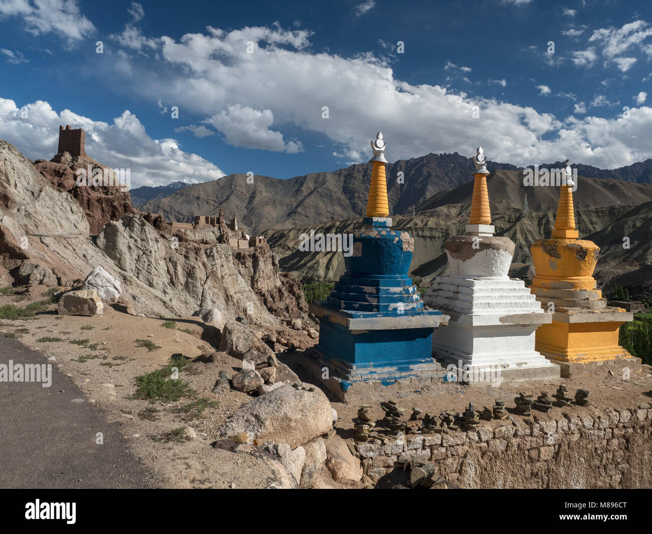 Three bright Buddhist stupas are blue, white and yellow on a high ...
