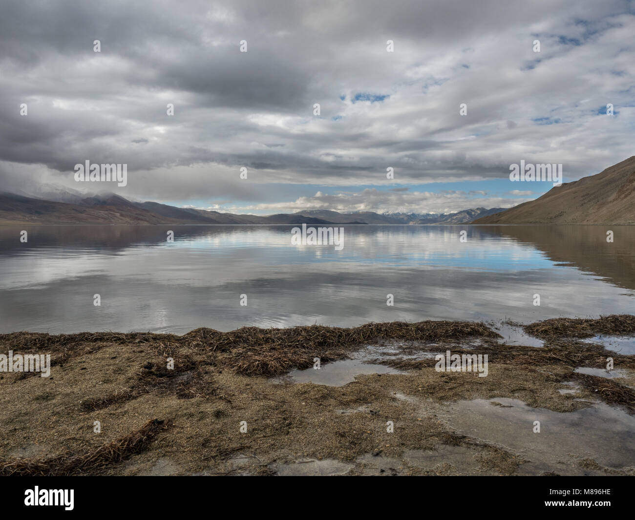 Thunderstorm on the mountain lake: the gray water's reflection reflects ...