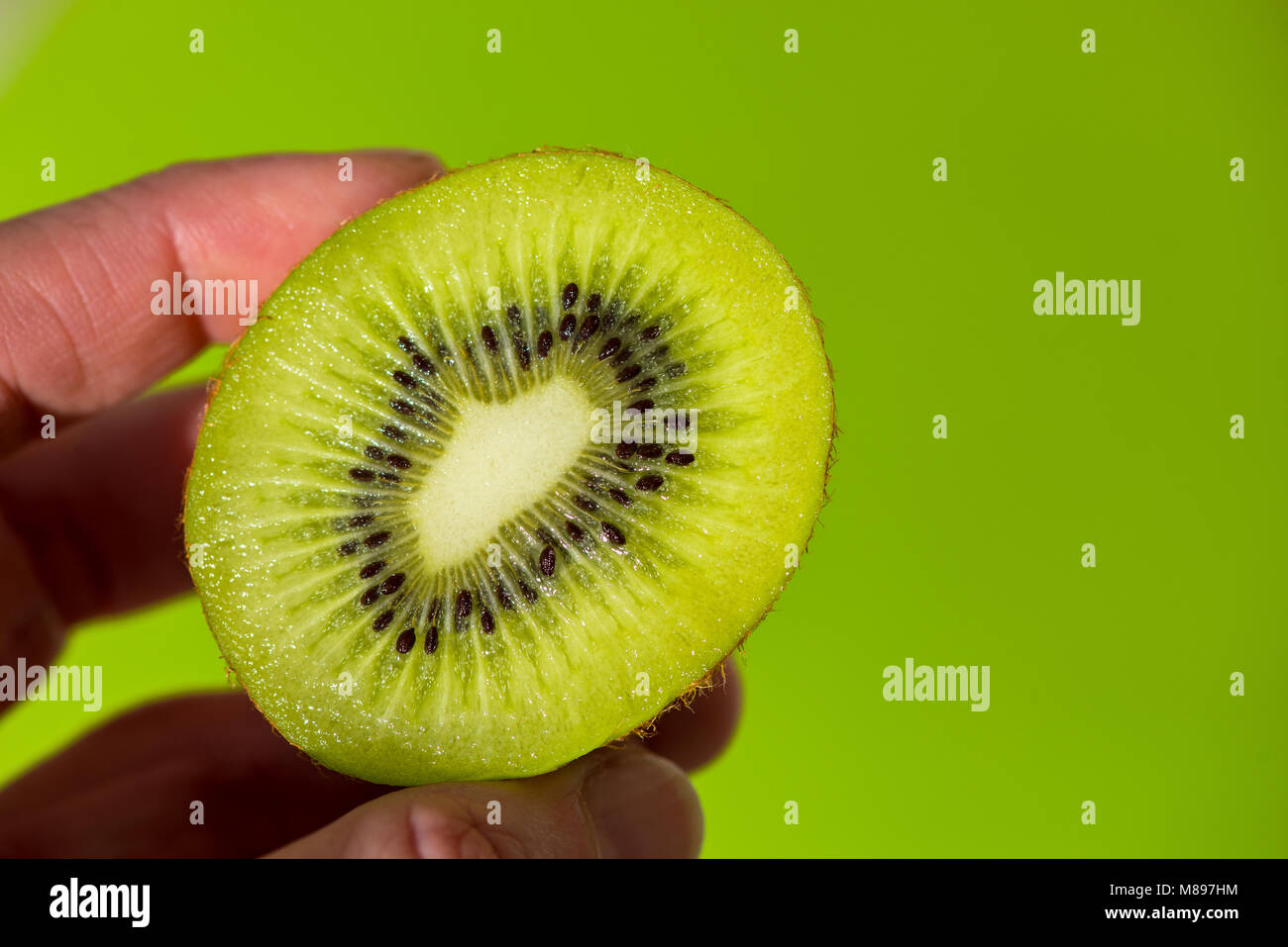 Kiwi fruit closeup on green background Stock Photo - Alamy