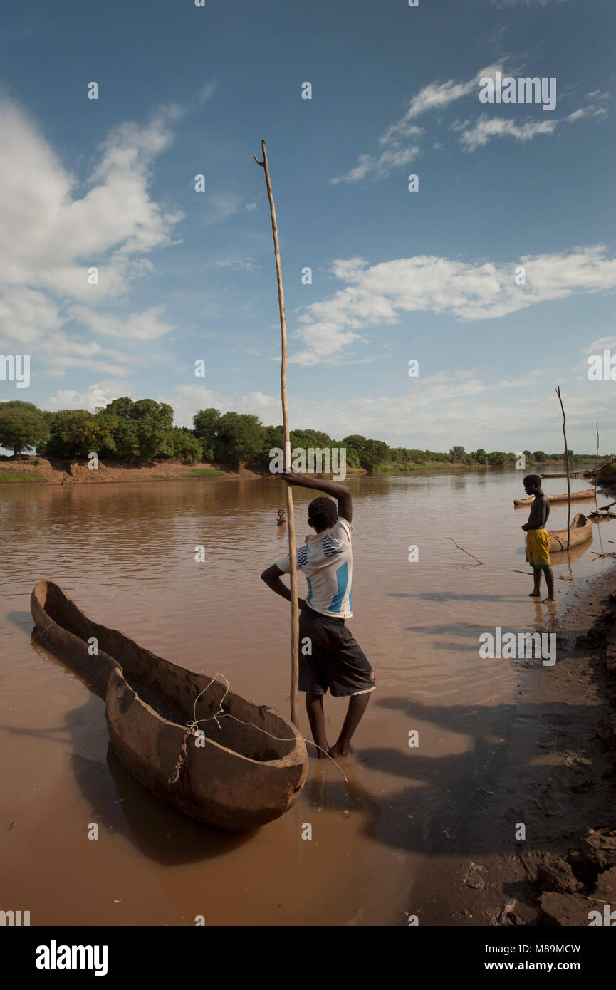 People are African tribes on the banks of the Omo River next to wooden ...