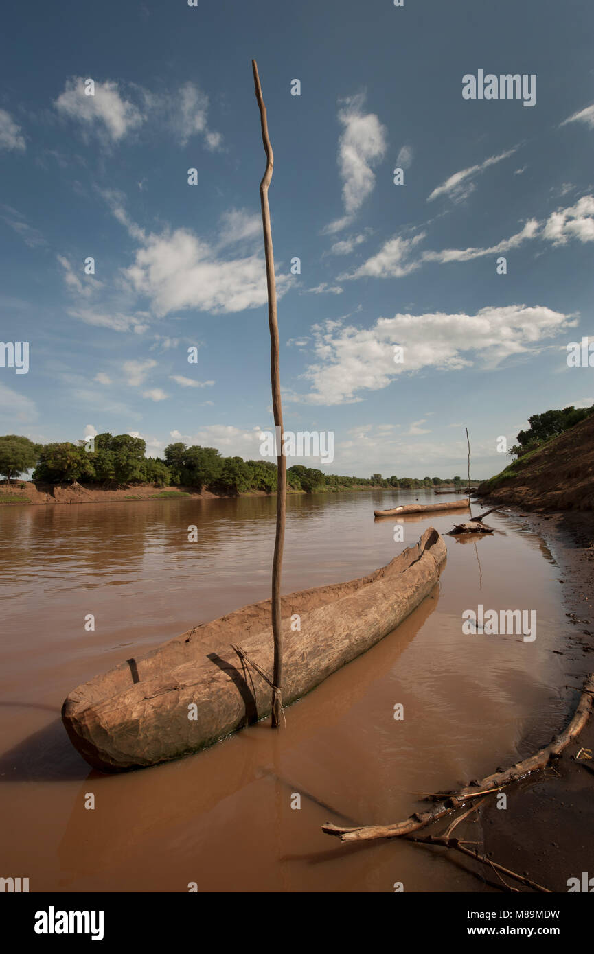 Long ethnic native boat canoe, hollowed out of a tree trunk, near a ...