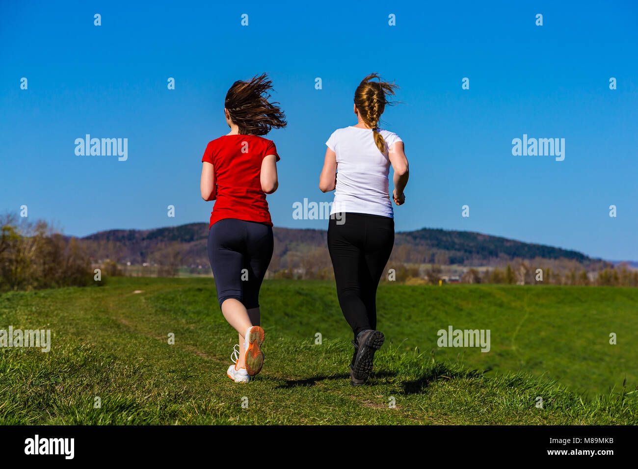 Mother and daughter running Stock Photo - Alamy
