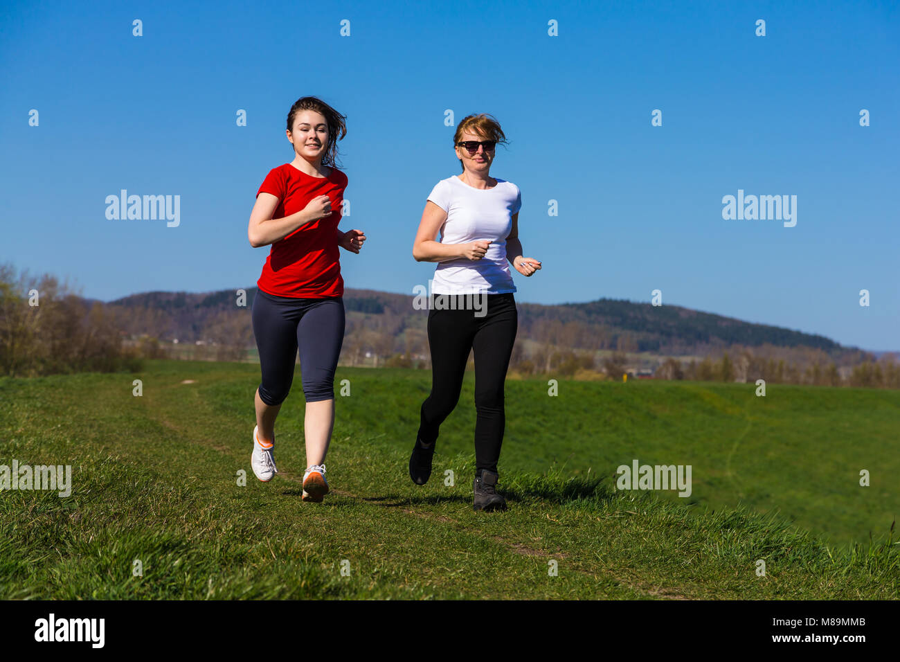 Mother and daughter running Stock Photo - Alamy