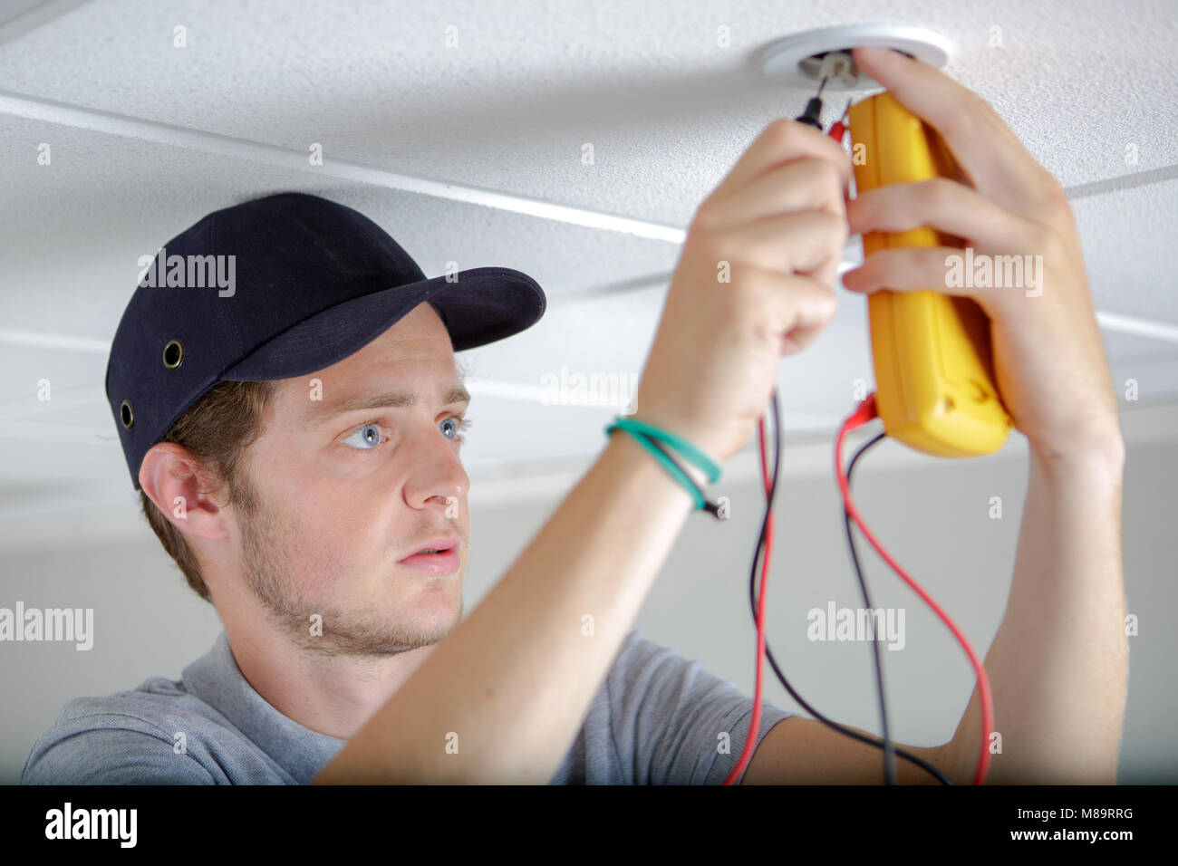 Man testing bulb holder with multimeter Stock Photo - Alamy