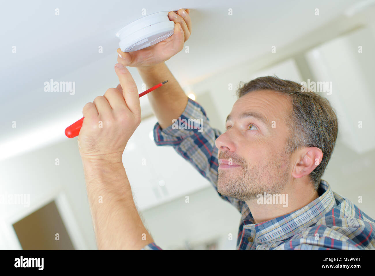 mid-adult man fixing light bulb wiring in new house Stock Photo - Alamy