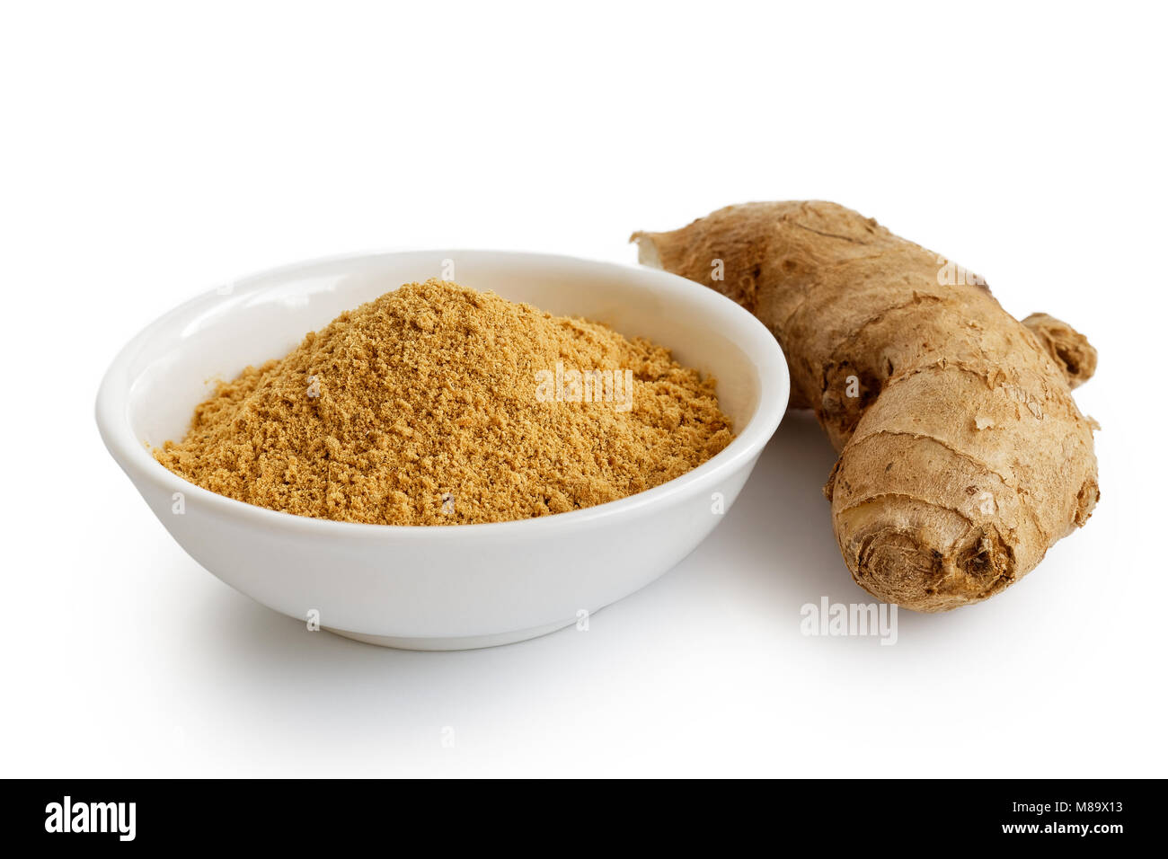 Finely ground dry ginger in white ceramic bowl isolated on white. Fresh ...