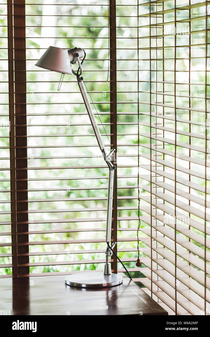 Metal high desk lamp in office, blinds on windows, minimalist style ...