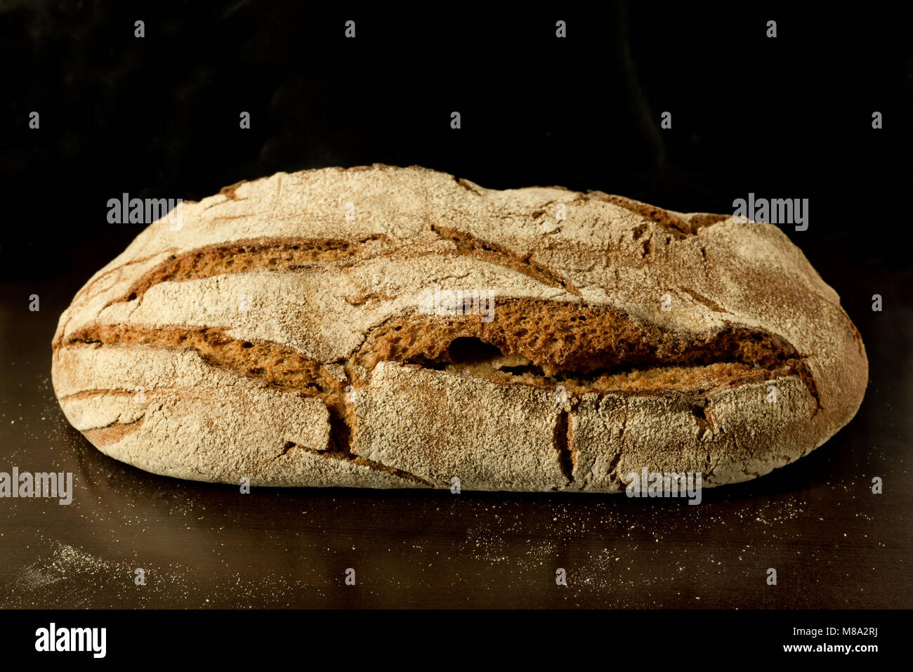 Whole loaf of fresh German sourdough rye bread on dark background Stock ...