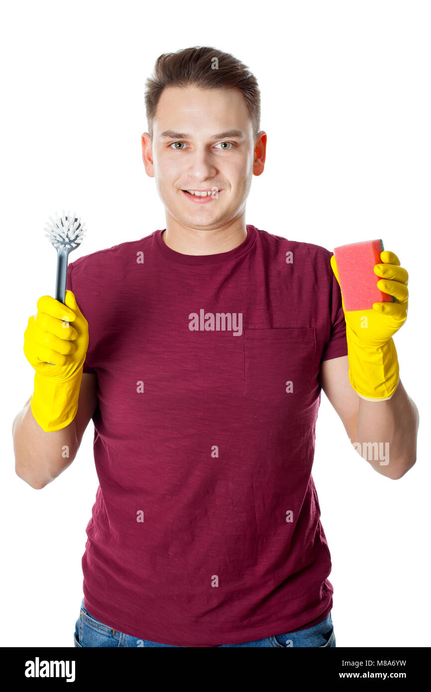 Young man wearing yellow gloves and holding cleaning supplies ...