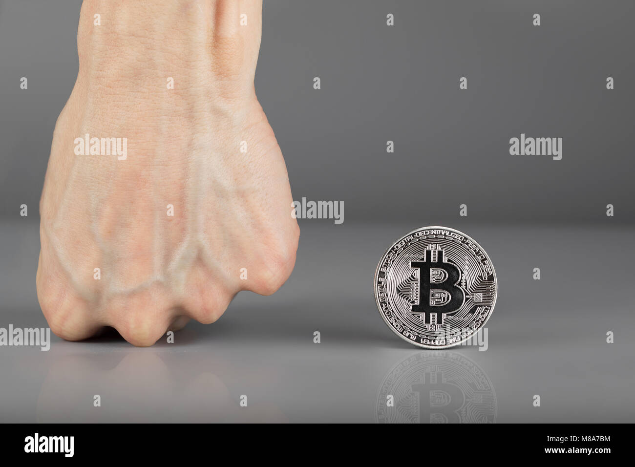 Human fist and bitcoin. Closeup Stock Photo - Alamy