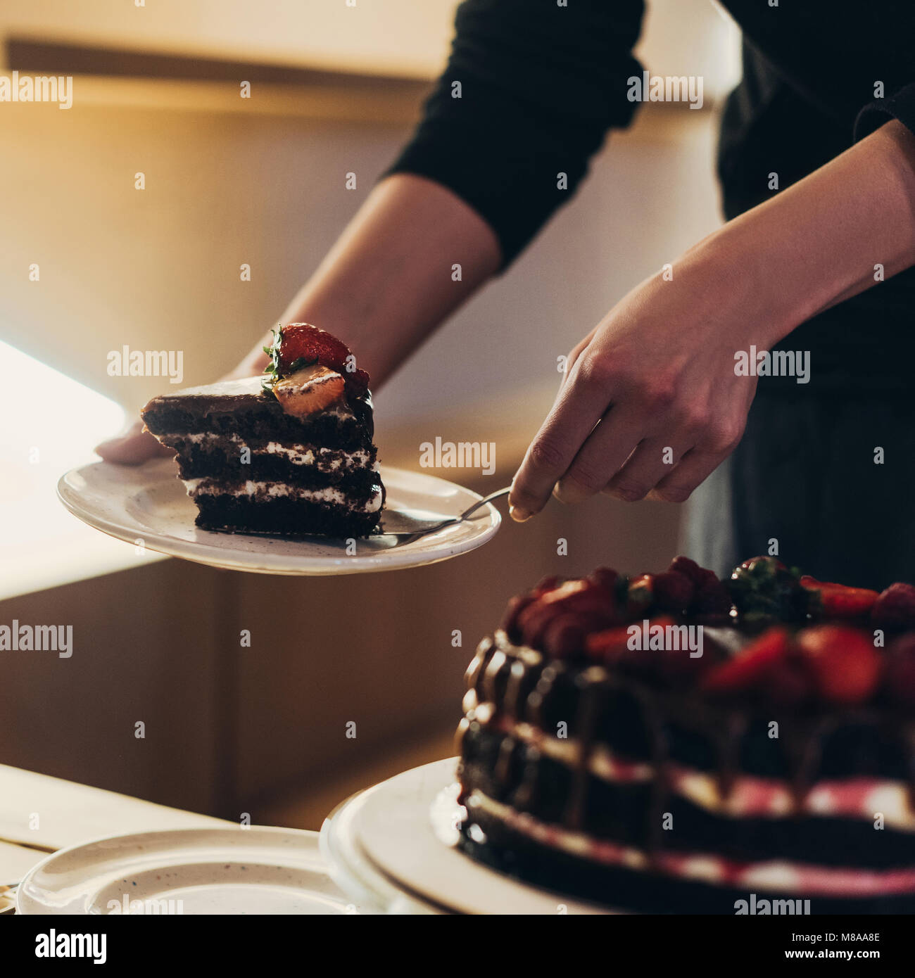 woman putting piece of cake on plate Stock Photo - Alamy