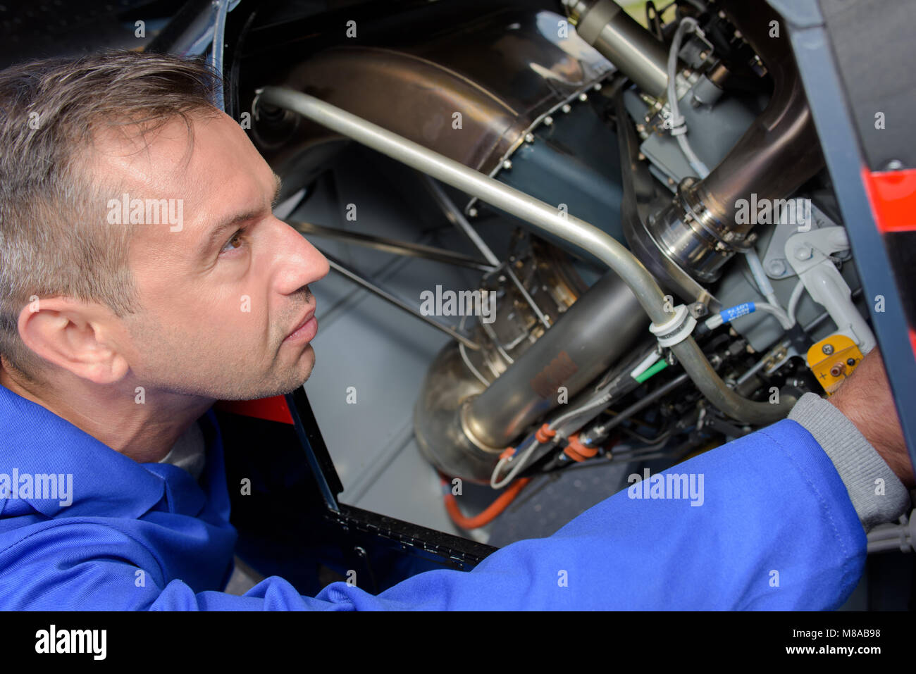 Mechanic working on engine Stock Photo - Alamy