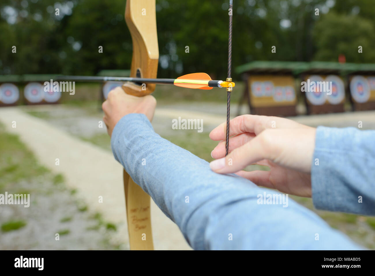 Hand poised to pull back string of bow and arrow Stock Photo - Alamy