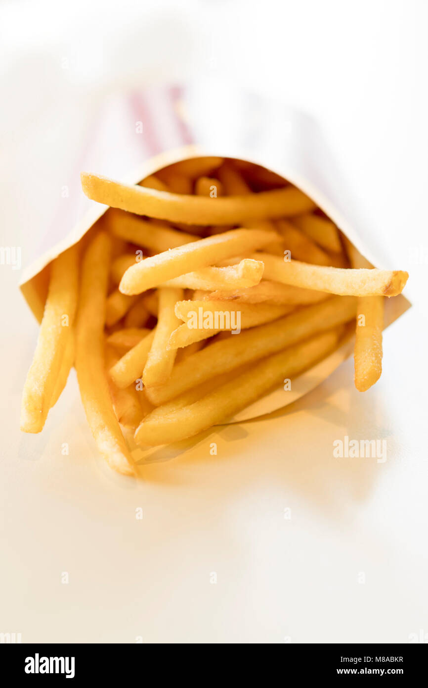 French fries in a box on a light background. Unhealthy food. Delicious ...
