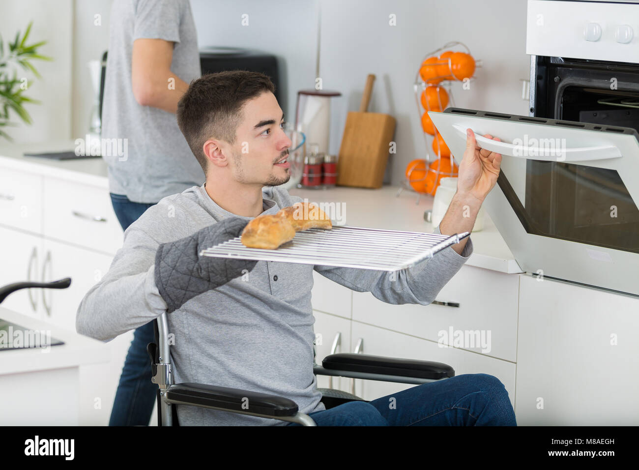 disabled young man in wheelchair opening the oven Stock Photo - Alamy