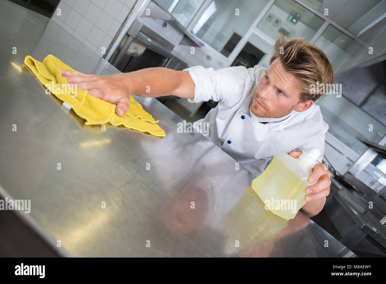 male cook wiping the counter top in the kitchen Stock Photo - Alamy