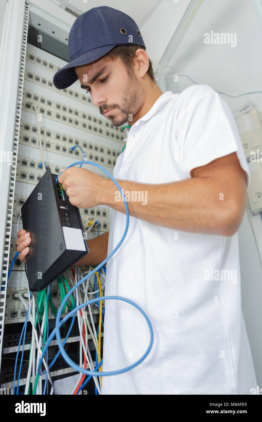 electrician connect internet server to the power board Stock Photo - Alamy