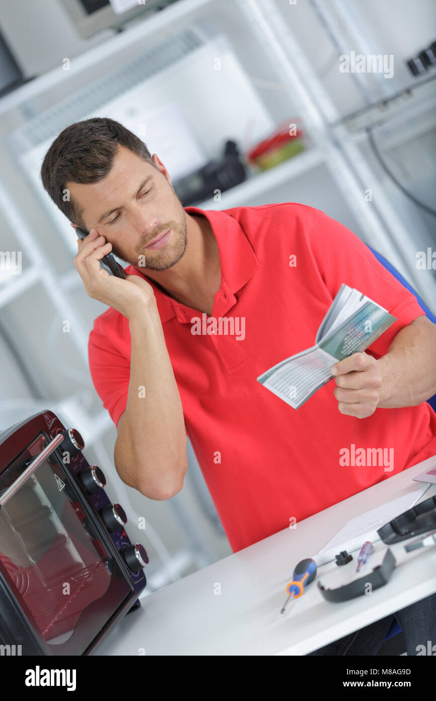 repairman on the phone with a client Stock Photo - Alamy