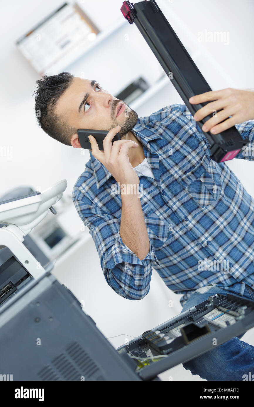 man inspecting a printer part Stock Photo - Alamy