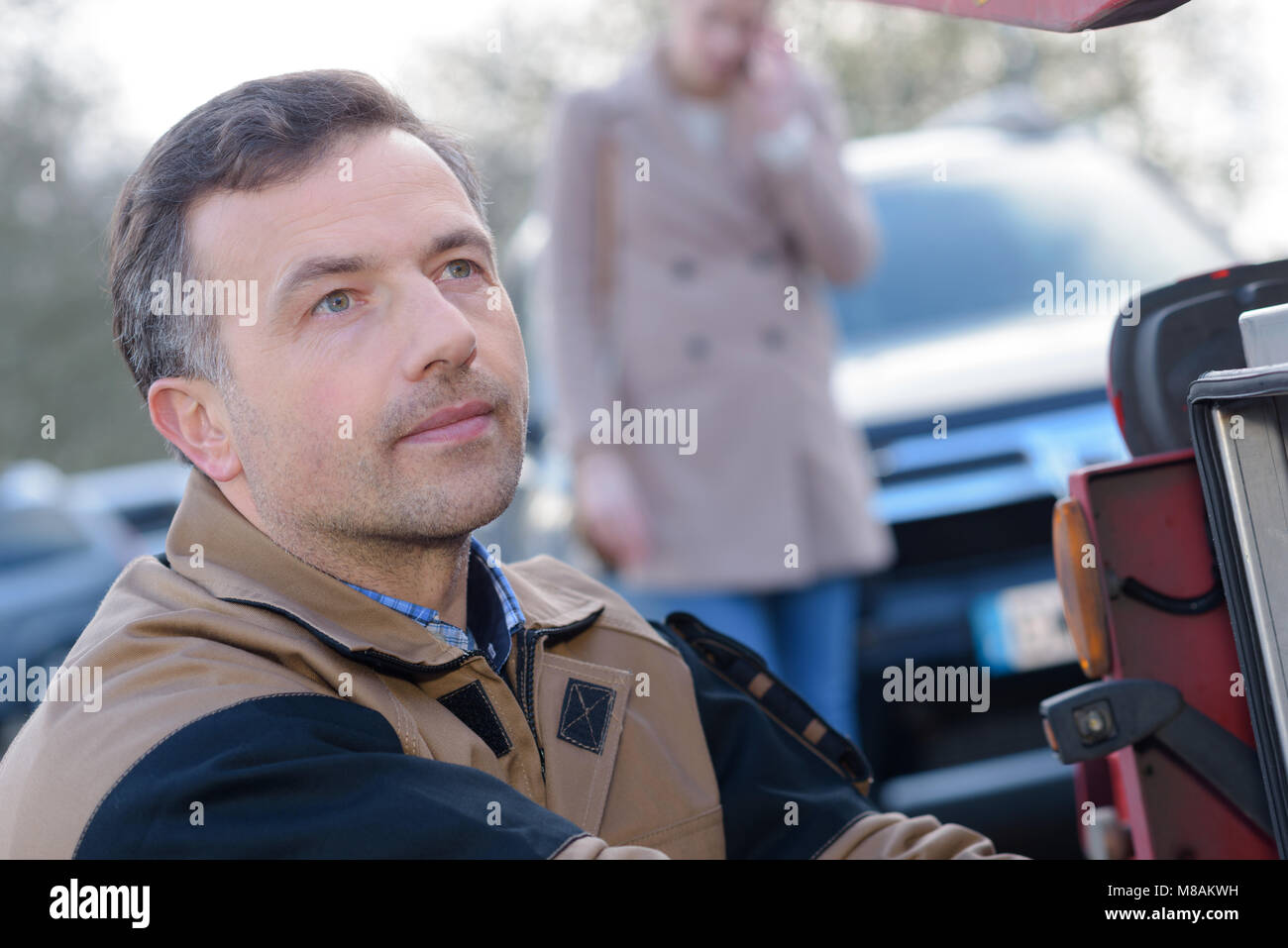 young woman and mechanic assistance on roadside with car breakdown ...