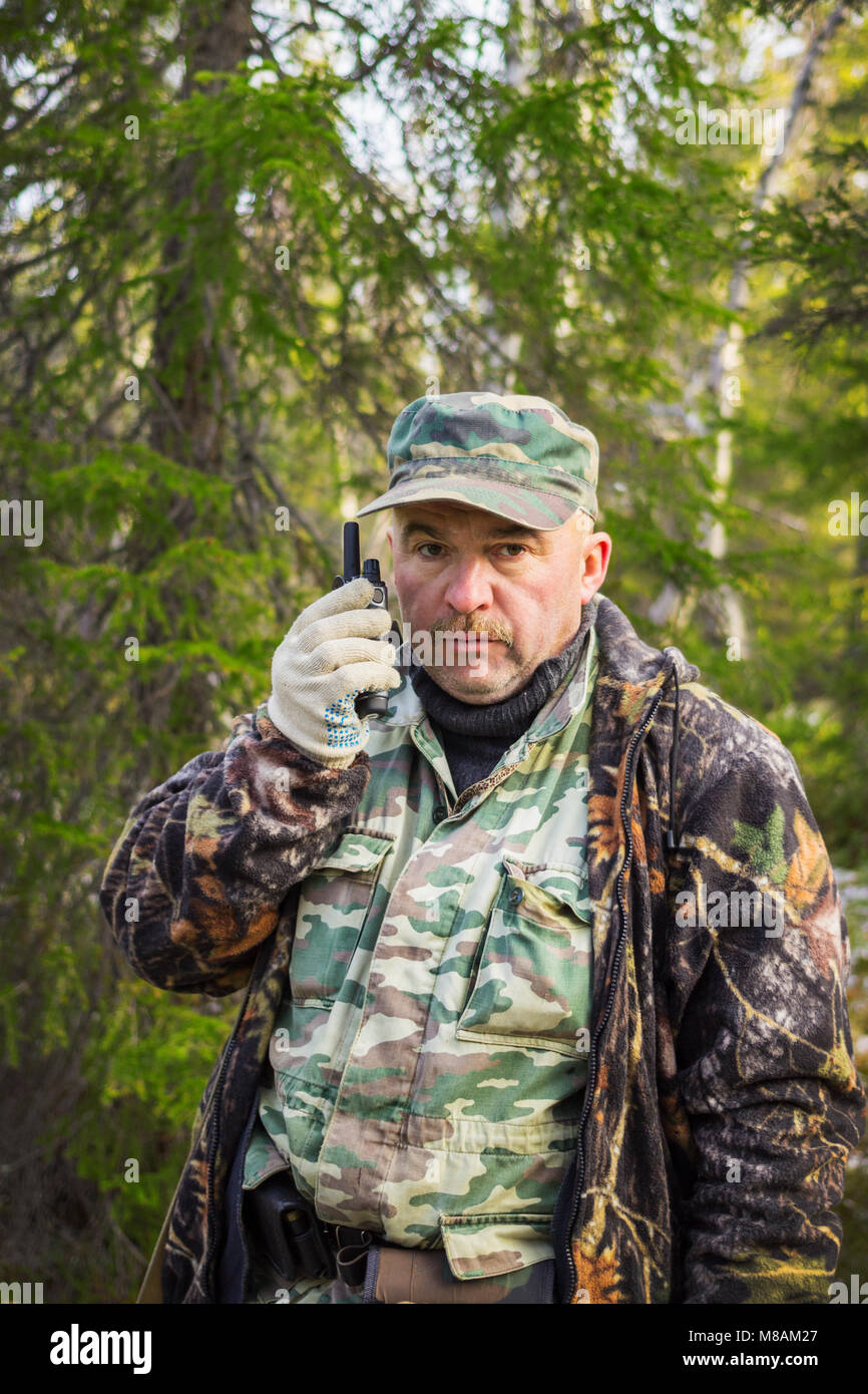 Ranger in forest talking on radio Stock Photo - Alamy