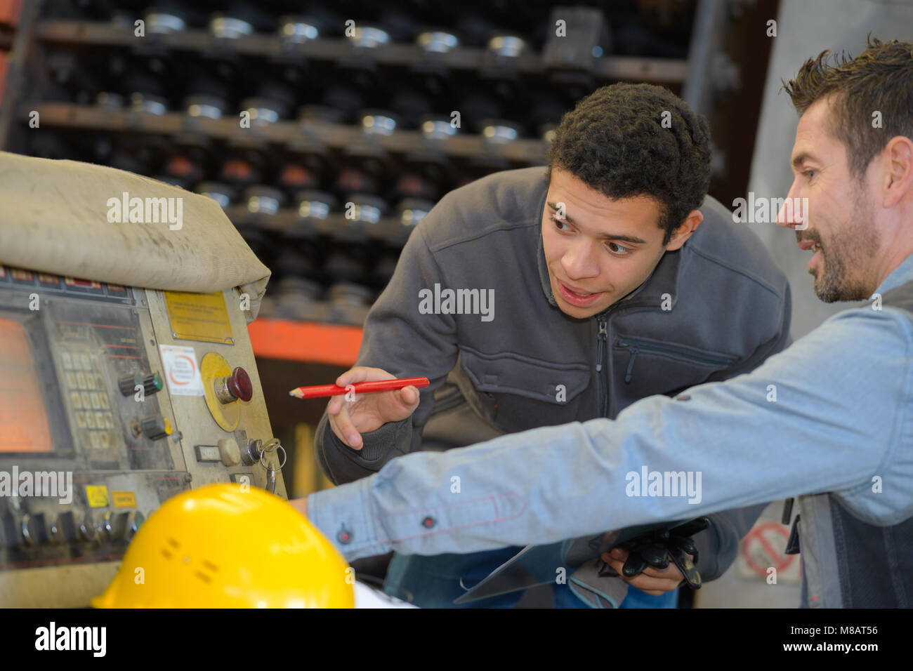 trainee learning how to use a machine at the factory Stock Photo - Alamy