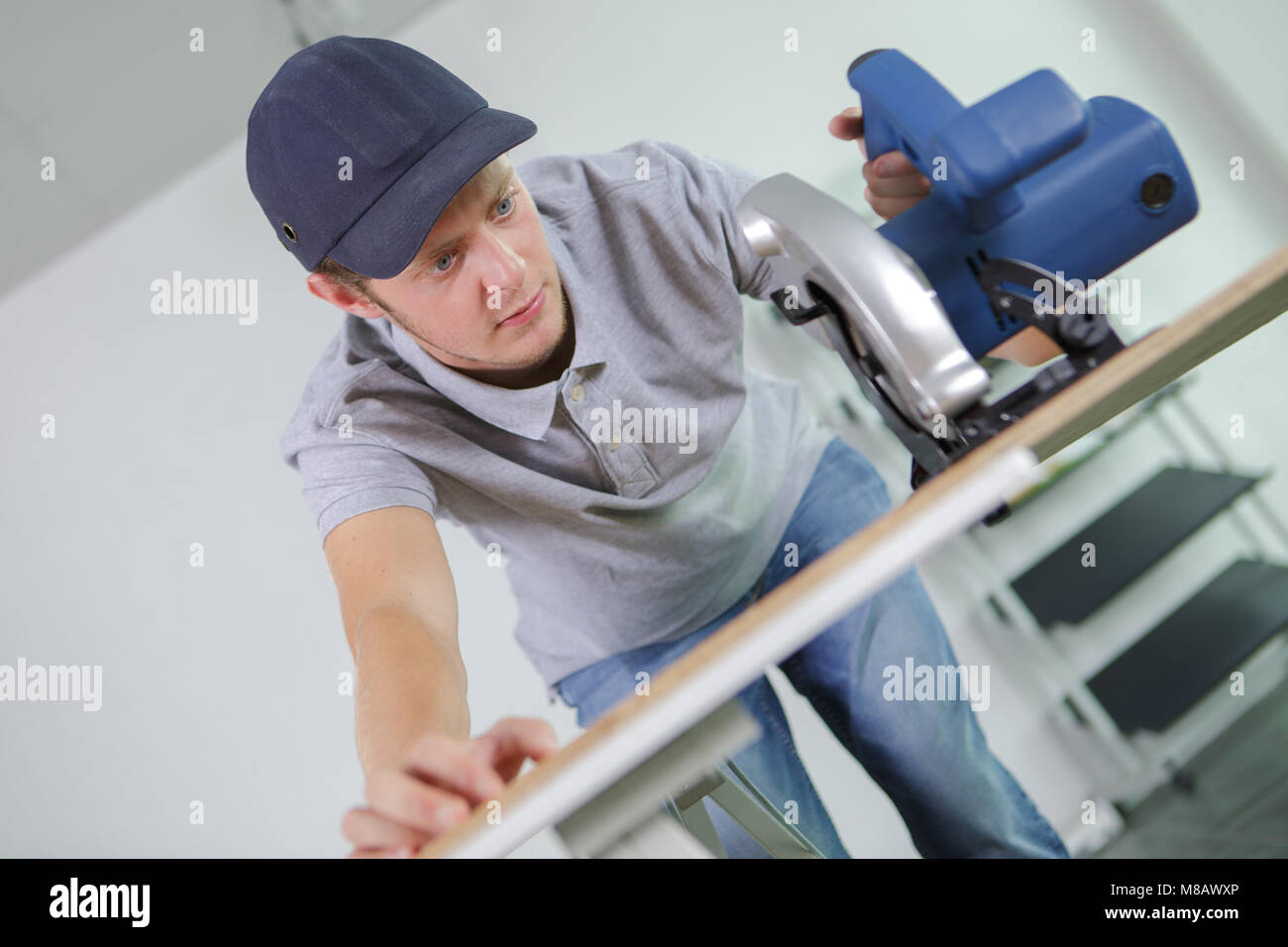Young man using circular saw on work bench Stock Photo - Alamy