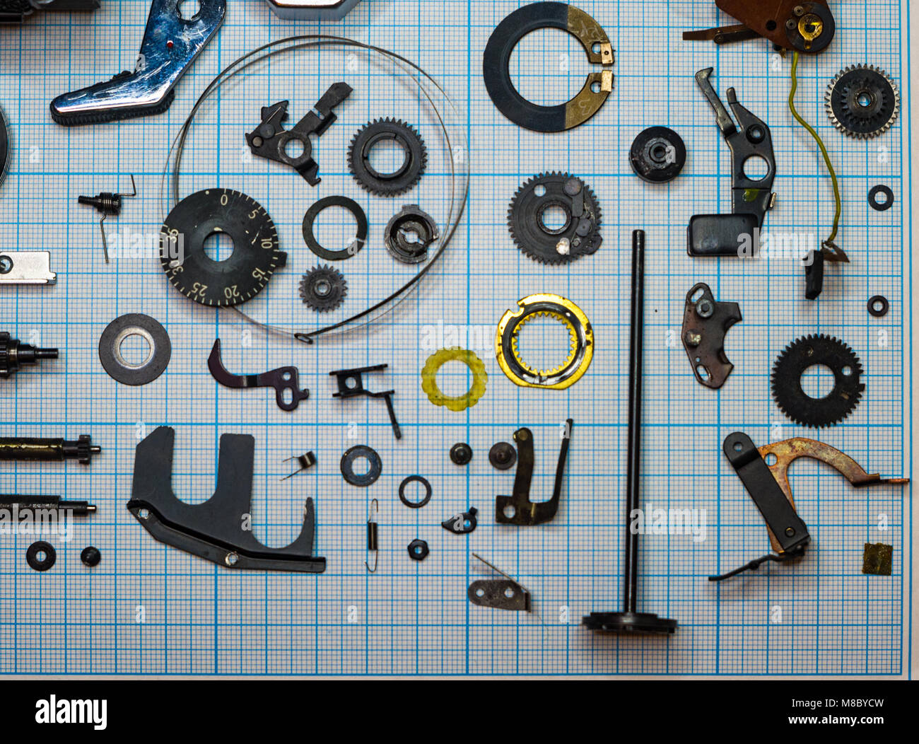 parts are completely disassembled old retro film SLR camera on graph ...