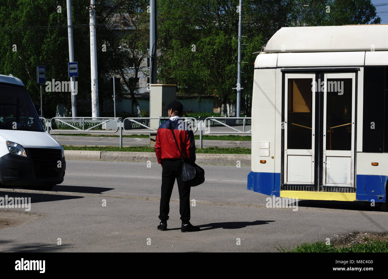 handsome young man waiting his bus at bus stop Stock Photo - Alamy